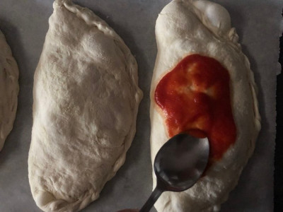 Calzone di pizza cotto al forno, ripieno di pomodoro e mozzarella ...